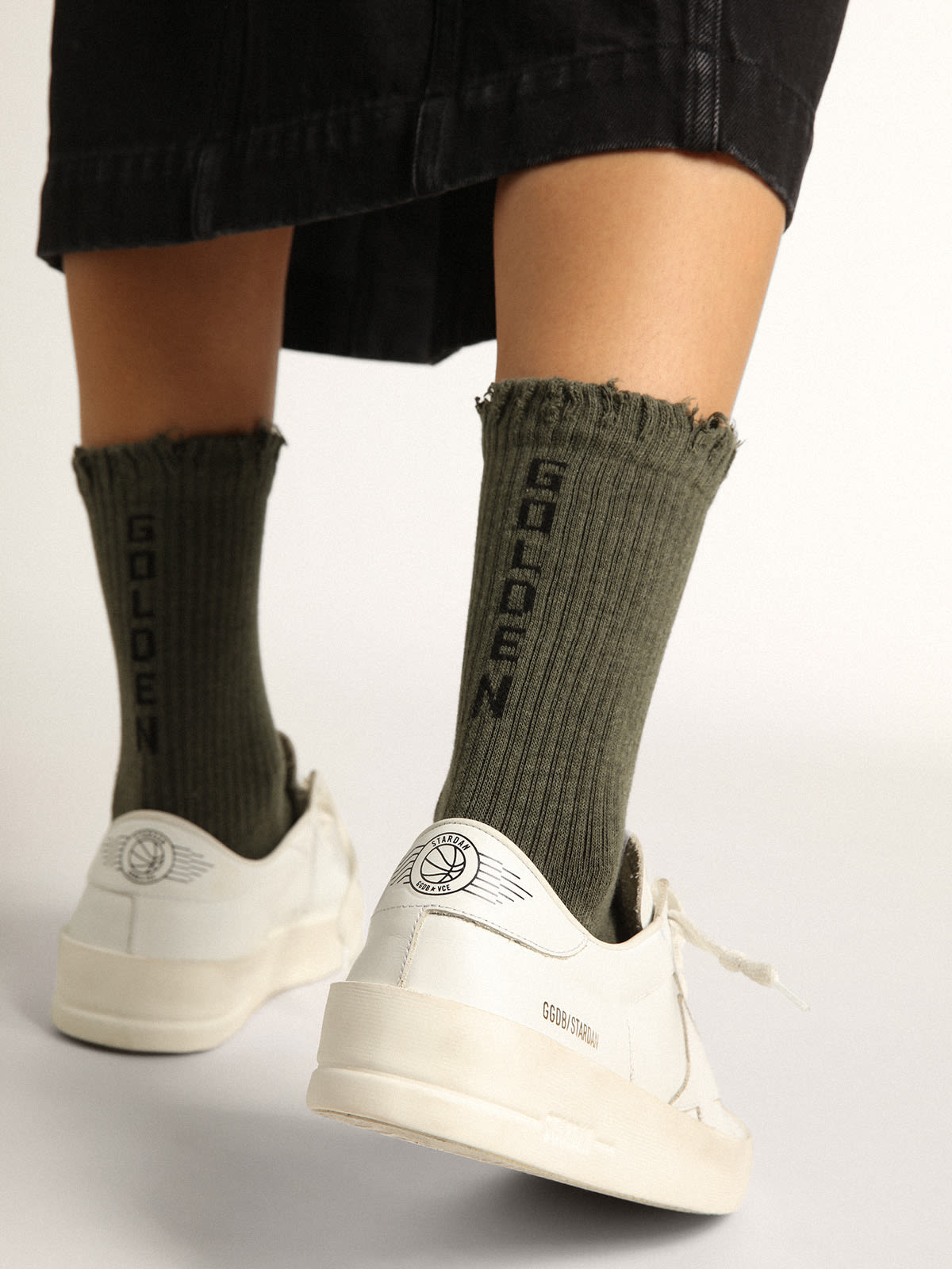Olive-green cotton socks with distressed finish and black ‘Golden’ lettering on the back ...